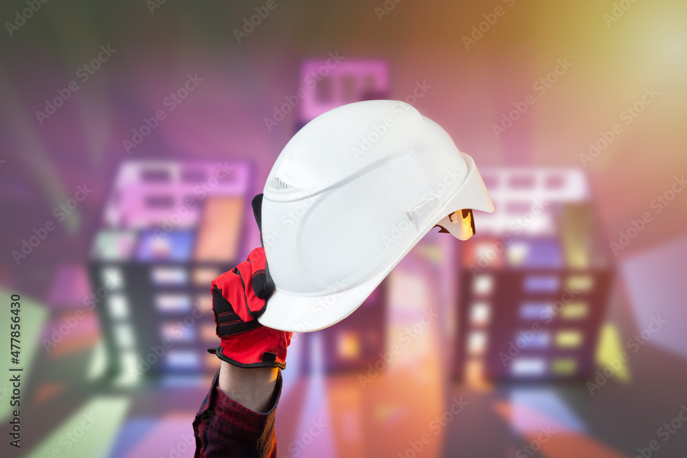 Hand with builder helmet. White builder helmet on a pink background ...