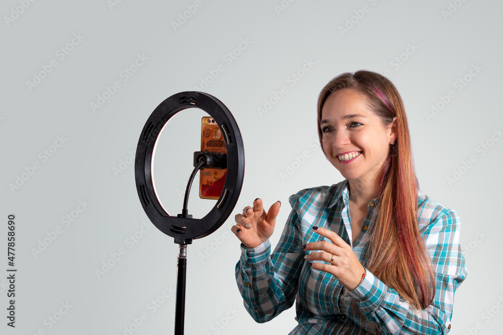 Mujer grabando videos para redes sociales, con su celular y su aro de ...
