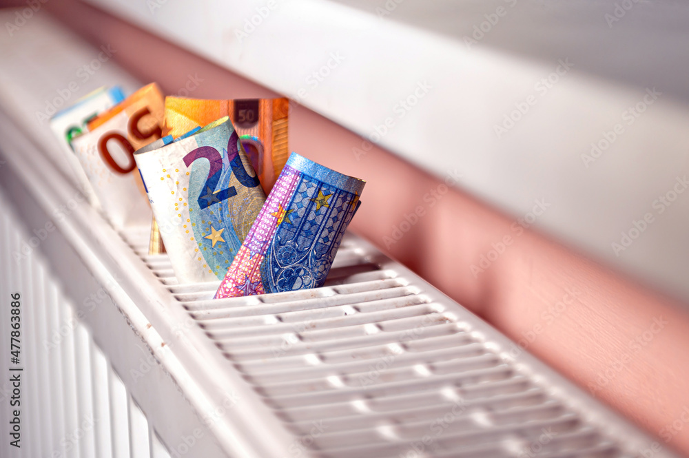 euro banknotes in a central heating radiator, the concept of expensive ...