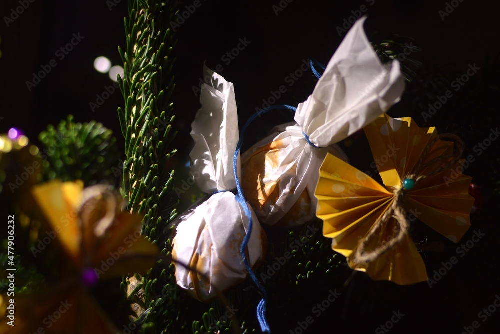 Wrapped gift on a hand-decorated spruce branch. Charming yellow paper ...