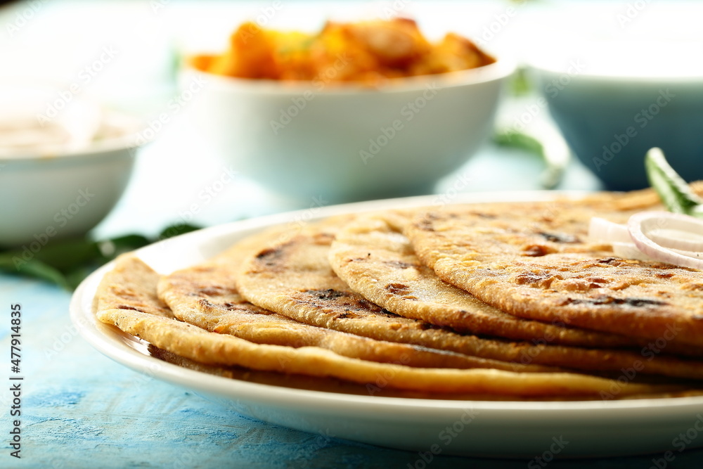 Punjabi dhaba style meal- aloo paratah with fresh raita and potato ...