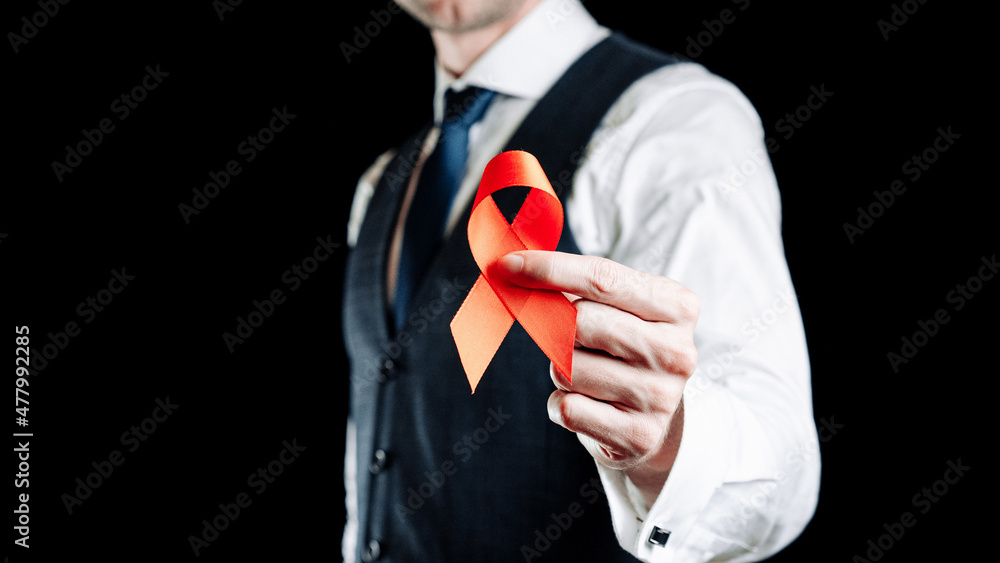 Hiv aids. Red ribbon in hiv world day isolated on dark background. Man ...