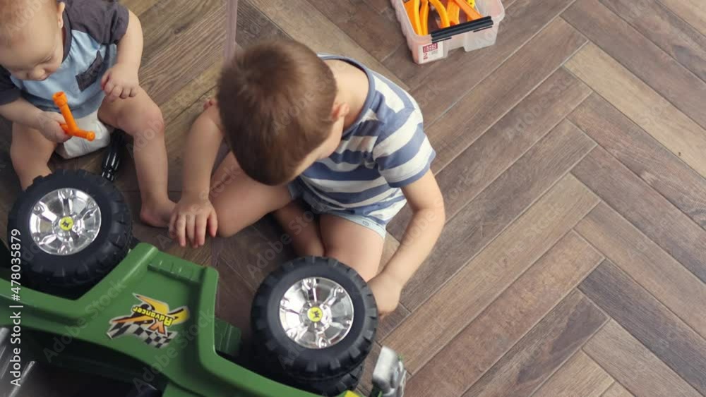 two little brothers kids playing repairing toy car as mechanic using ...
