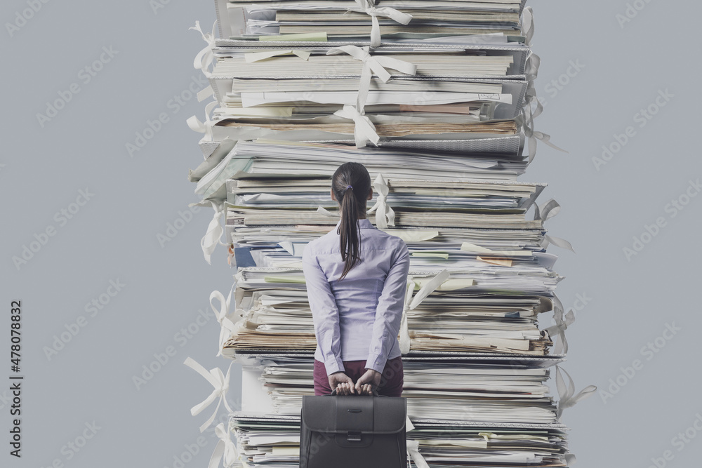 Frustrated businesswoman staring at a huge pile of paperwork Stock ...
