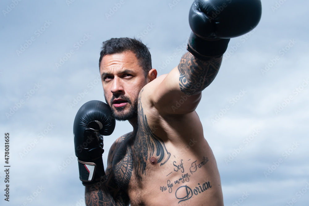 Boxer in a fight. Fist fight. Strong man with tattooed body boxing ...