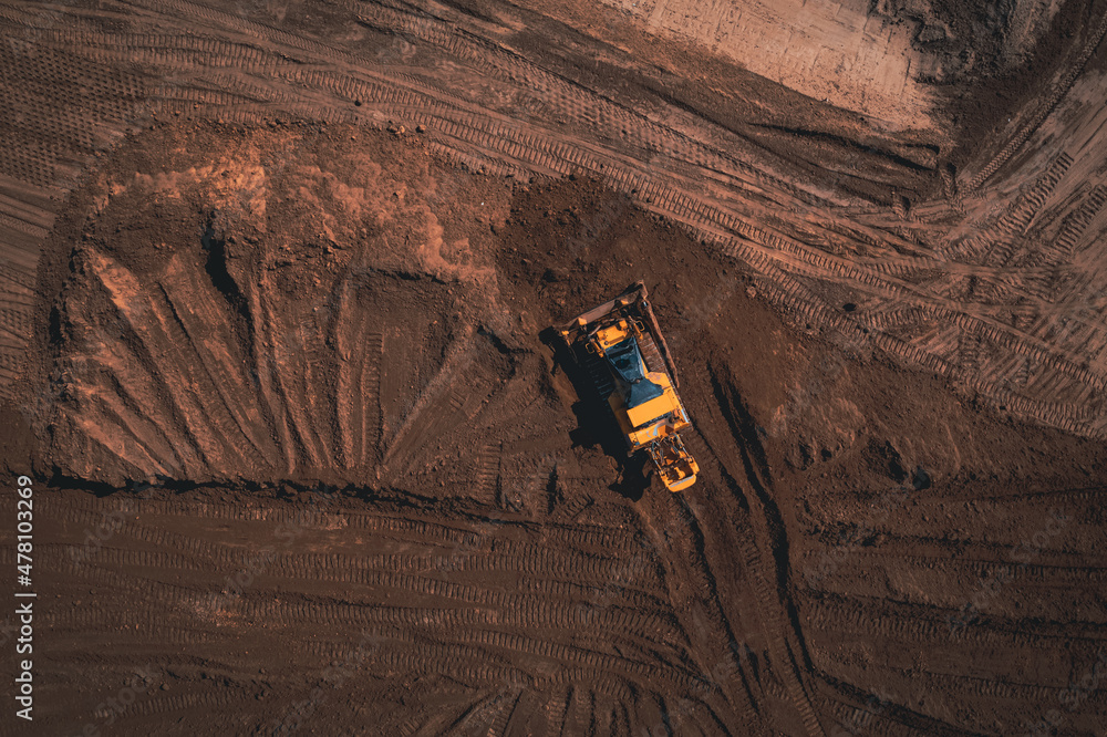 Yellow tracked bulldozer performs earthworks - aerial view shot. Yellow ...