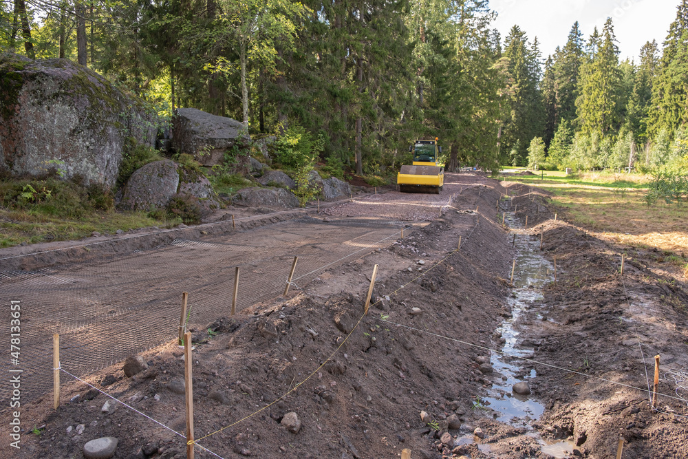 The excavator digs a trench for laying a storm drain and a grid for ...