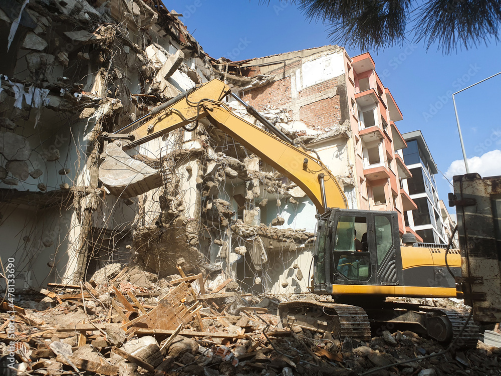 Building demolition excavator with long mechanical arm. Destruction of ...