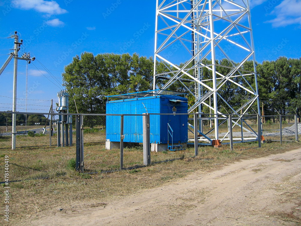 The metal structure of the cell tower behind the fence. Blue control ...