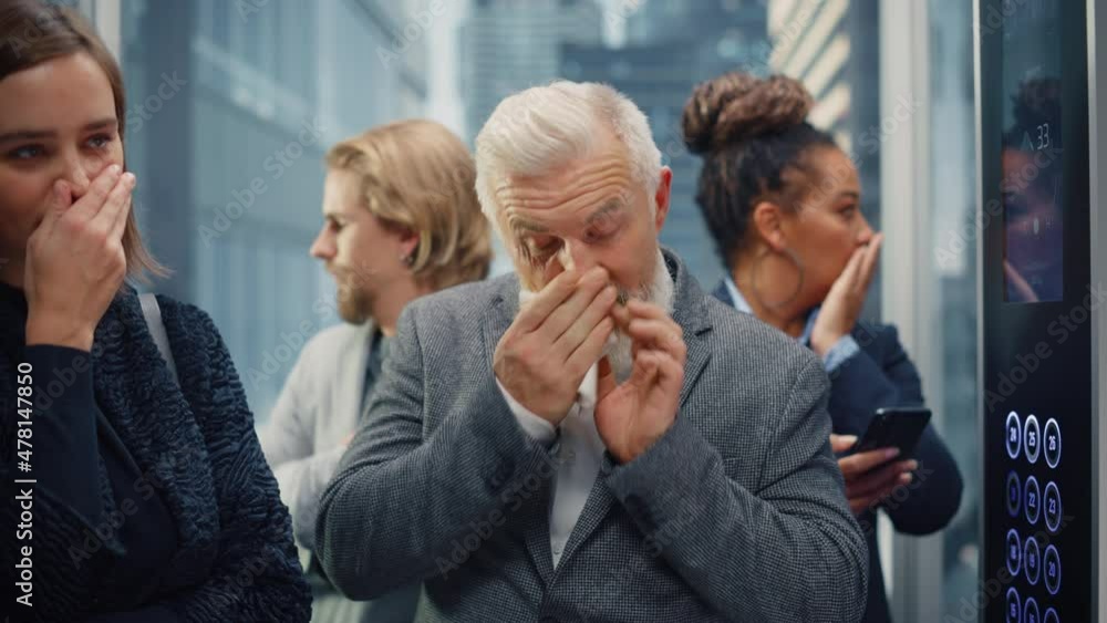 Video Stock Middle Aged Man Sneezes in a Crowded Glass Elevator in a ...