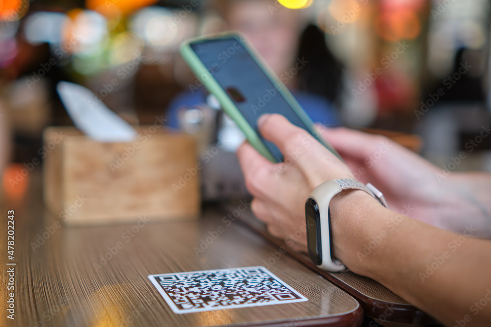 Closeup of guest hand ordering meal in restaurant while scanning qr ...