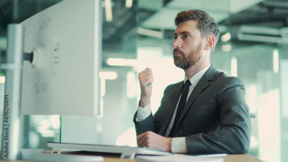 Portrait thoughtful male businessman working on pc computer at a modern ...