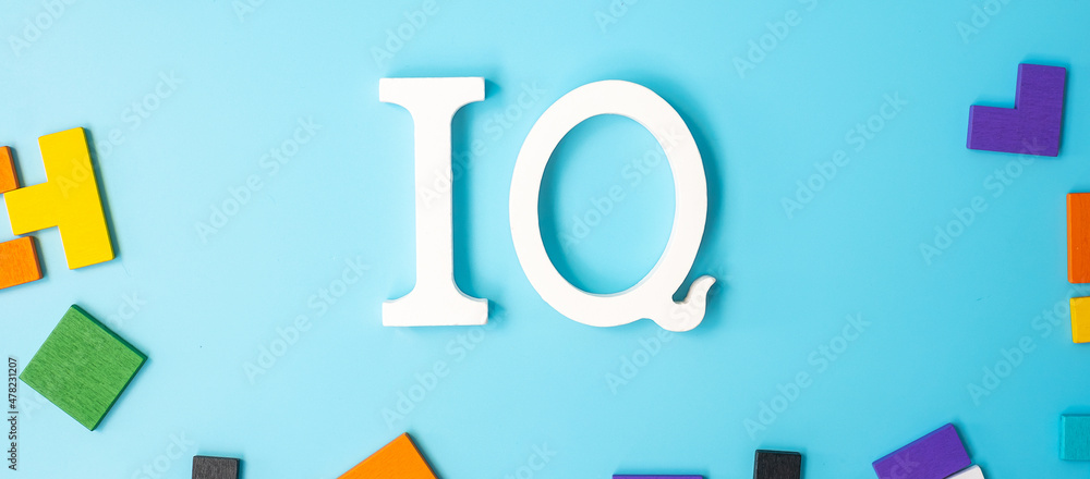 IQ text with colorful wood puzzle pieces, geometric shape block on blue ...