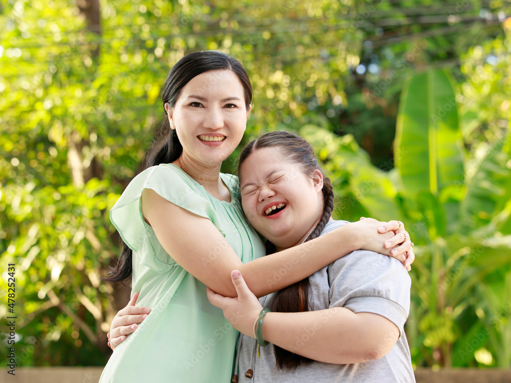 Portrait shot of Asian mother and young chubby down syndrome autistic ...
