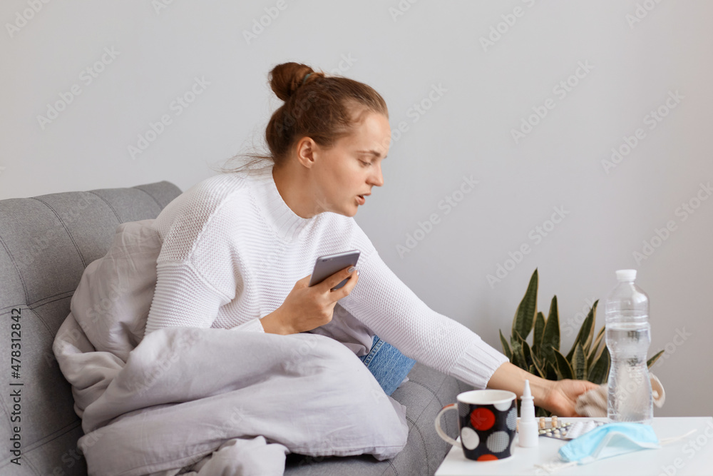 Profile portrait of sick female with bun hairstyle wearing white ...