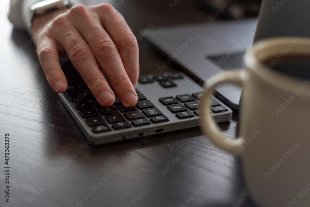 Using a peripheral numeric keypad next to laptop on desk. Stock Photo ...