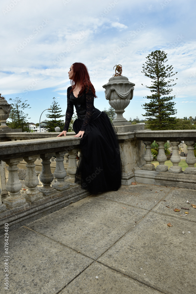 portrait of pretty female model with red hair wearing glamorous gothic ...