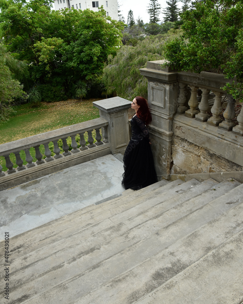 portrait of pretty female model with red hair wearing glamorous gothic ...
