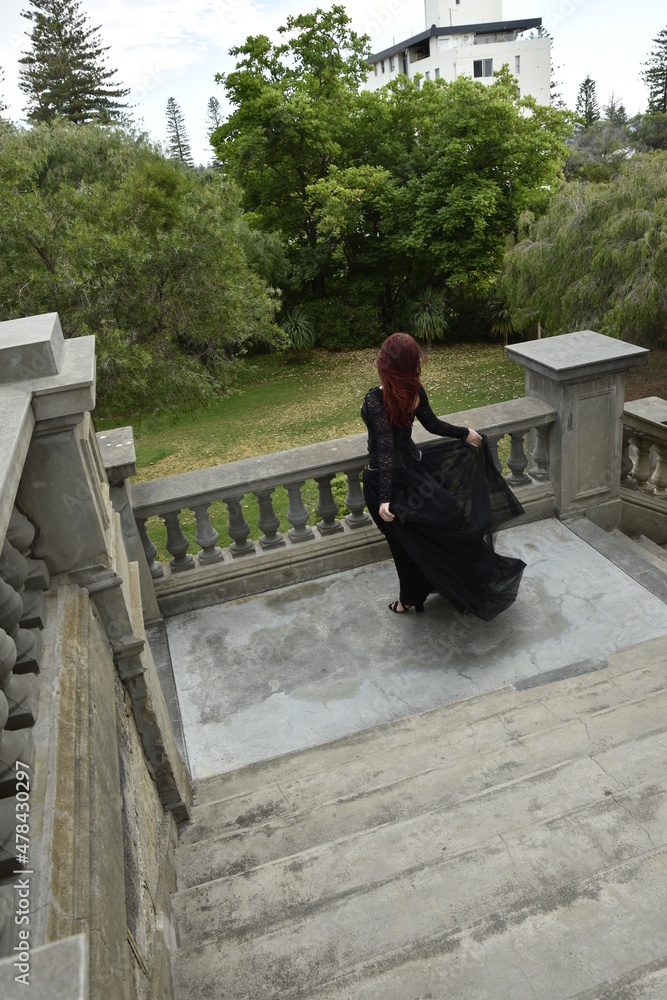 portrait of pretty female model with red hair wearing glamorous gothic ...