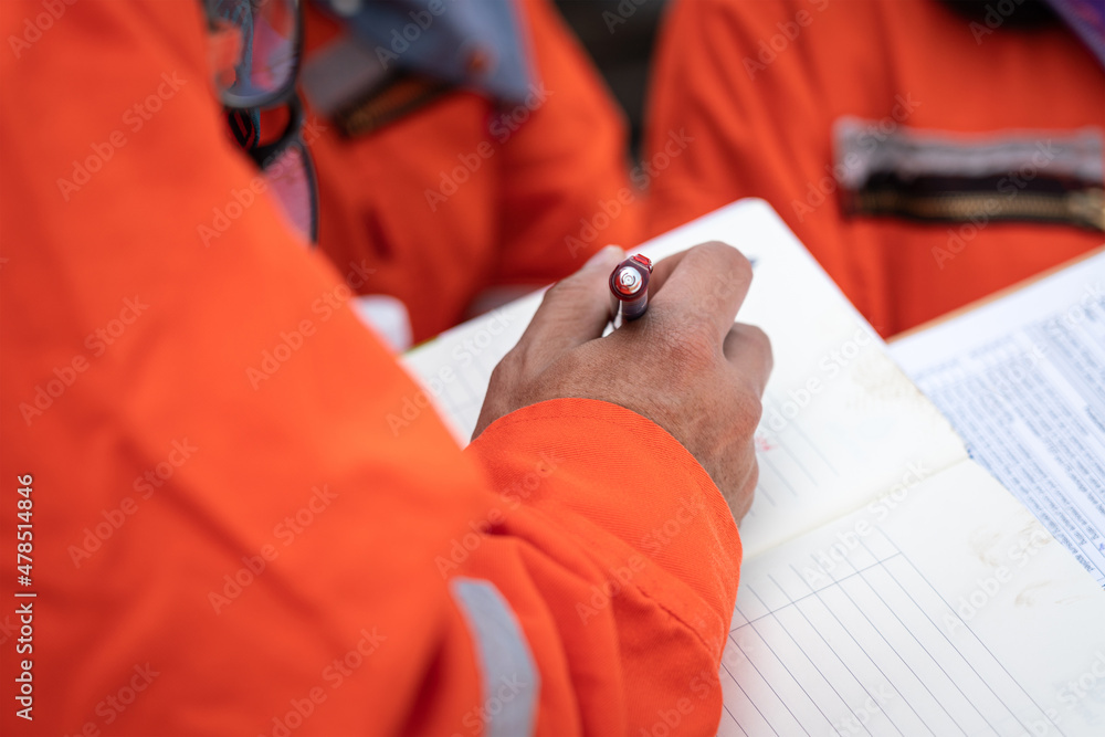 Foto de A supervisor is taking note on paper during perform inspection ...
