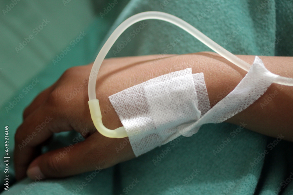 Female patient with iv on hand in the hospital. An Asian female patient ...