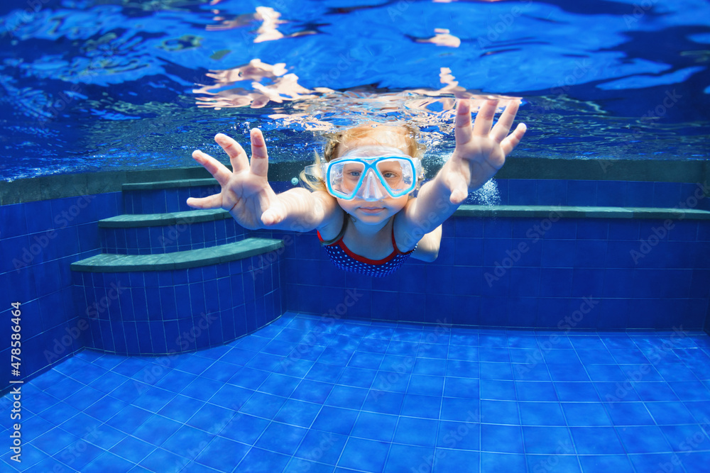 Funny portrait of child learning swimming, dive in blue pool with fun ...