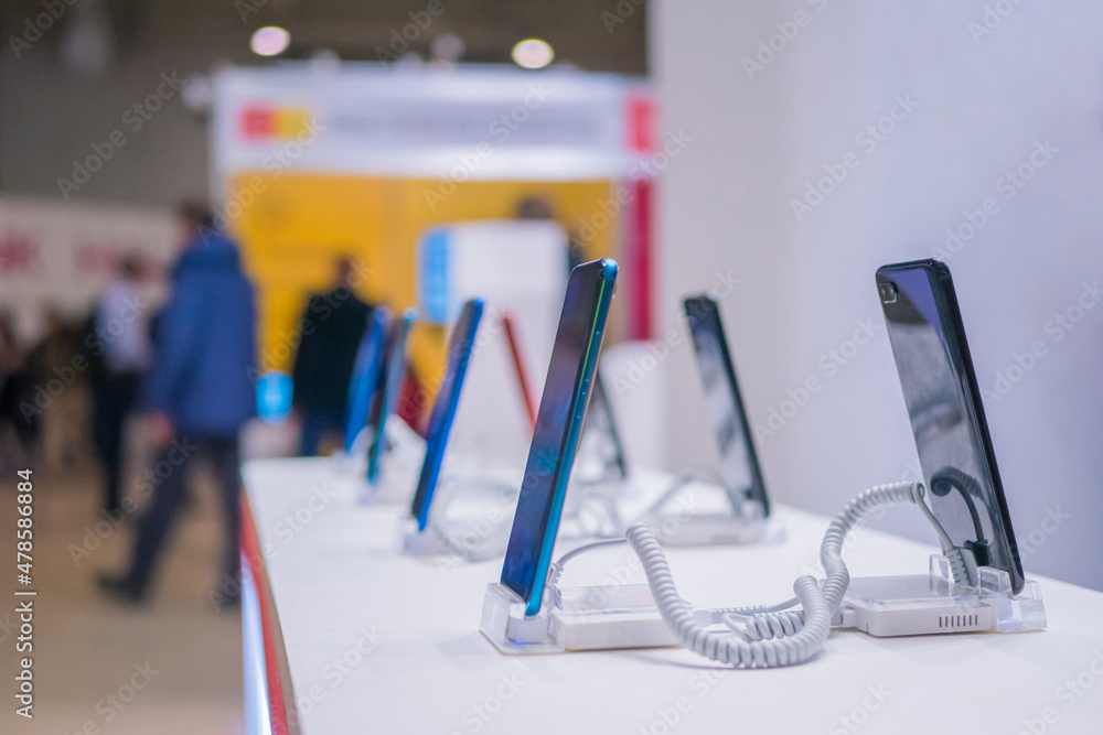 New models of smartphone in modern electronic shop, store. Blurry ...