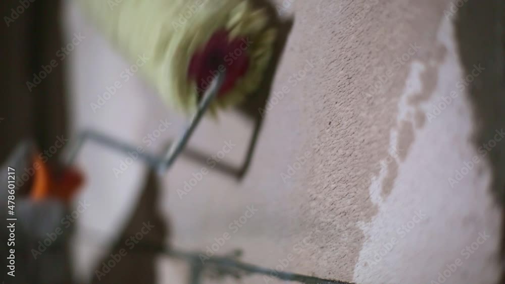 Applying a liquid primer coating a construction roller is preparation ...