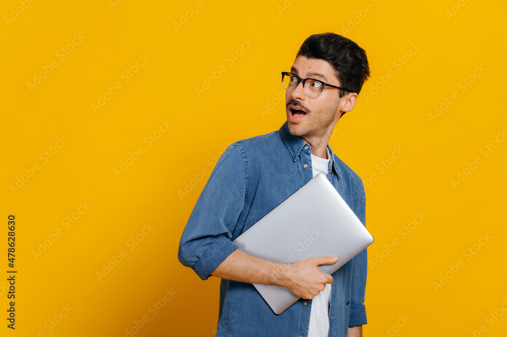 Surprised shocked caucasian stylish smart guy with glasses, is holding ...