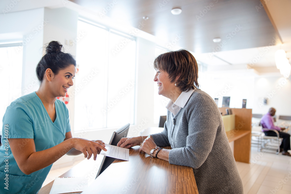 Female patient paying insurance copay with credit card reader at clinic ...