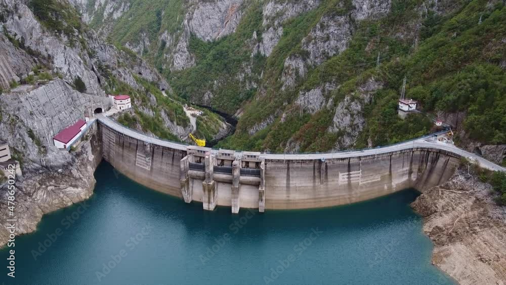 Bird's eye view of dam with sky blue water in mountains. Deep mountain ...
