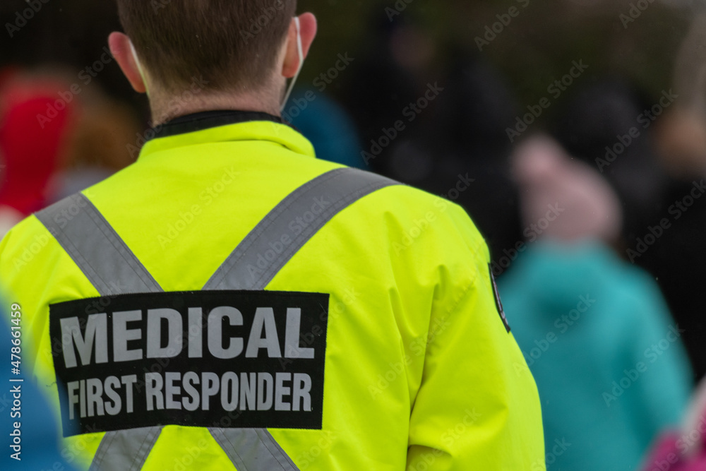 Medical first responders walking along a road wearing black wool ...