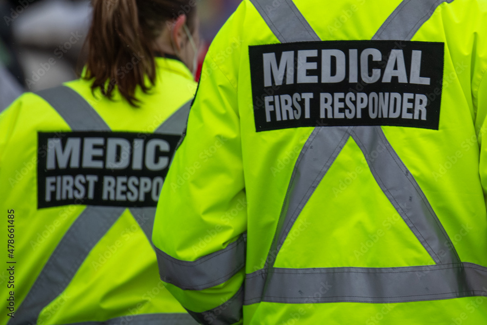 Medical first responders walking along a road wearing black wool ...