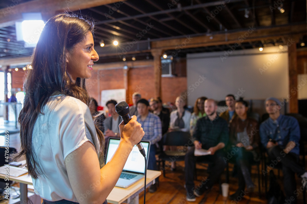 Female speaker giving presentation to group in conference room Stock ...