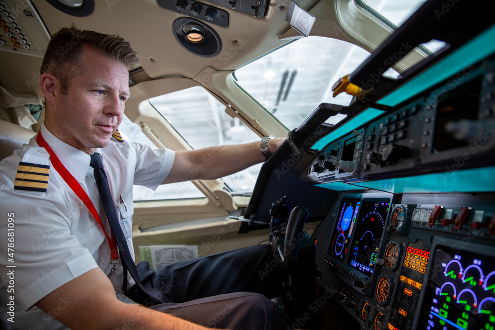 Male pilot checking logbook in airplane cockpit Stock Photo | Adobe Stock