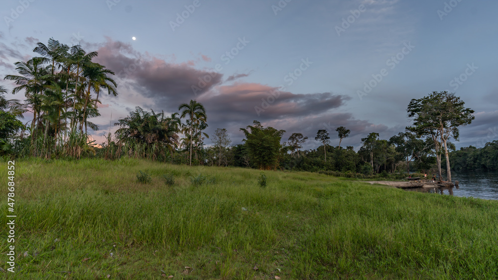 Reflection of a sunset by a lagoon inside the Amazon Rainforest Basin ...