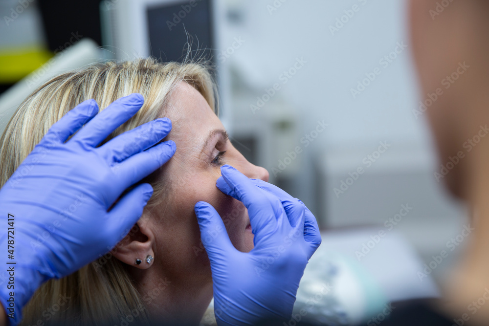 Technician giving woman botox injection corner of eye Stock Photo ...