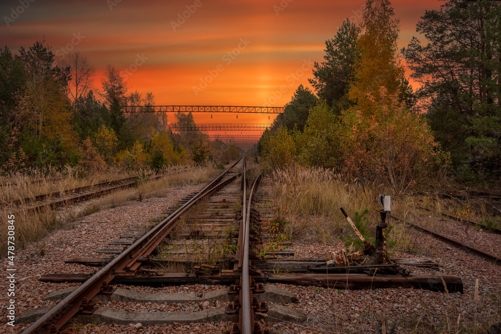 Ukraine, Kyiv Oblast, Chernobyl, Abandoned railroad tracks at fiery ...