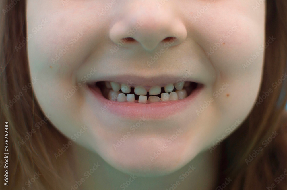 Сhild's smile is close. A small smiling child is a girl, her first baby ...