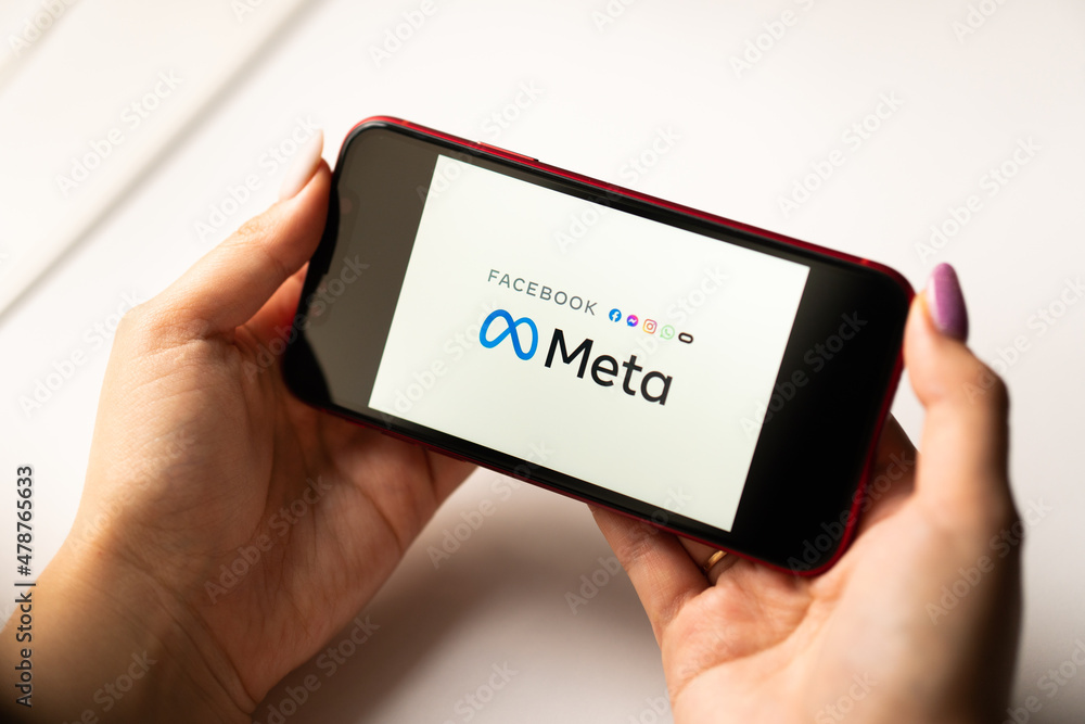 META logo on smartphone being held in hand in front of phone with ...