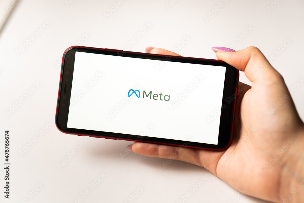 META logo on smartphone being held in hand in front of phone with ...