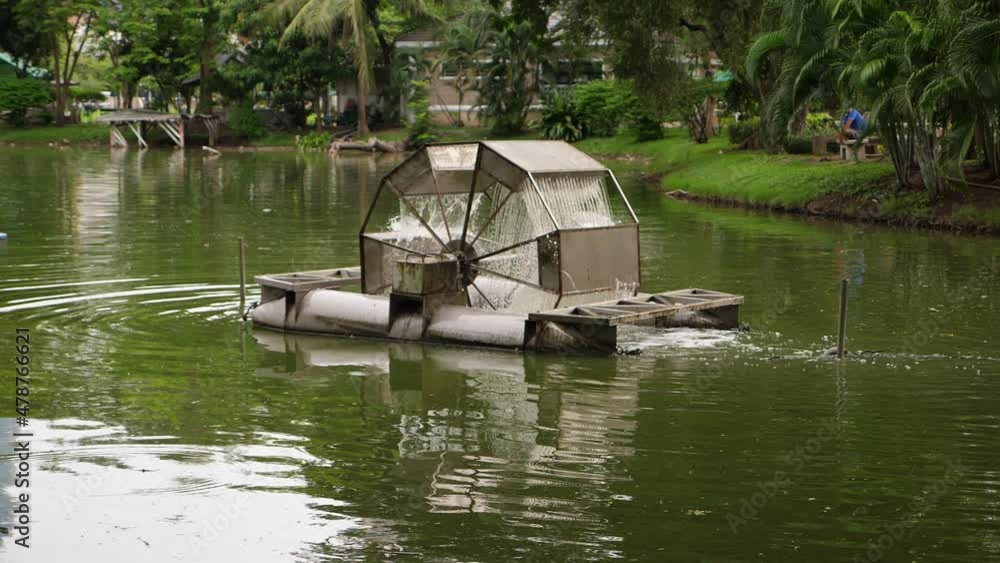 Floating aerator machine work on green water of lake in Lumphini park ...