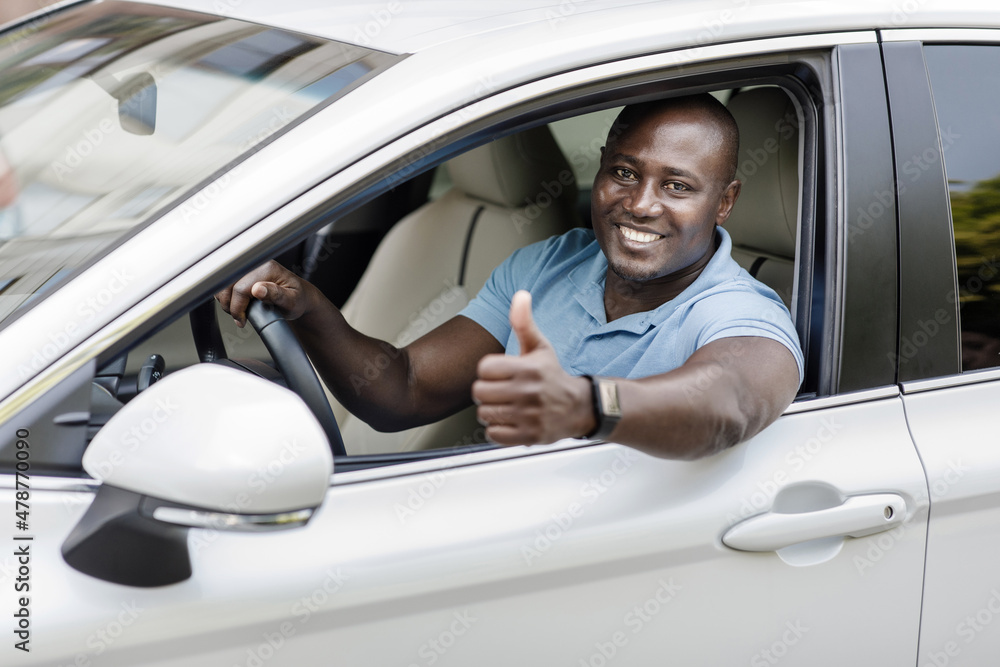Happy black man driving luxury white car, showing thumb up Stock Photo ...