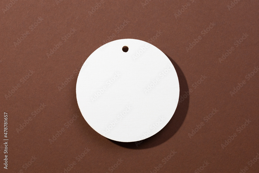 One white colored cardboard brand blank tag of circle shape with little ...
