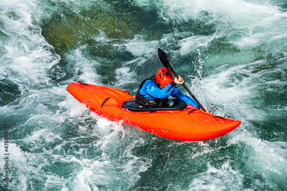 River kayaker in red kayak are paddling whitewatered river. Extreme ...