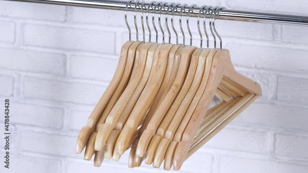 Vidéo Stock Lots of wooden hangers on rack metal bar in walk-in closet ...