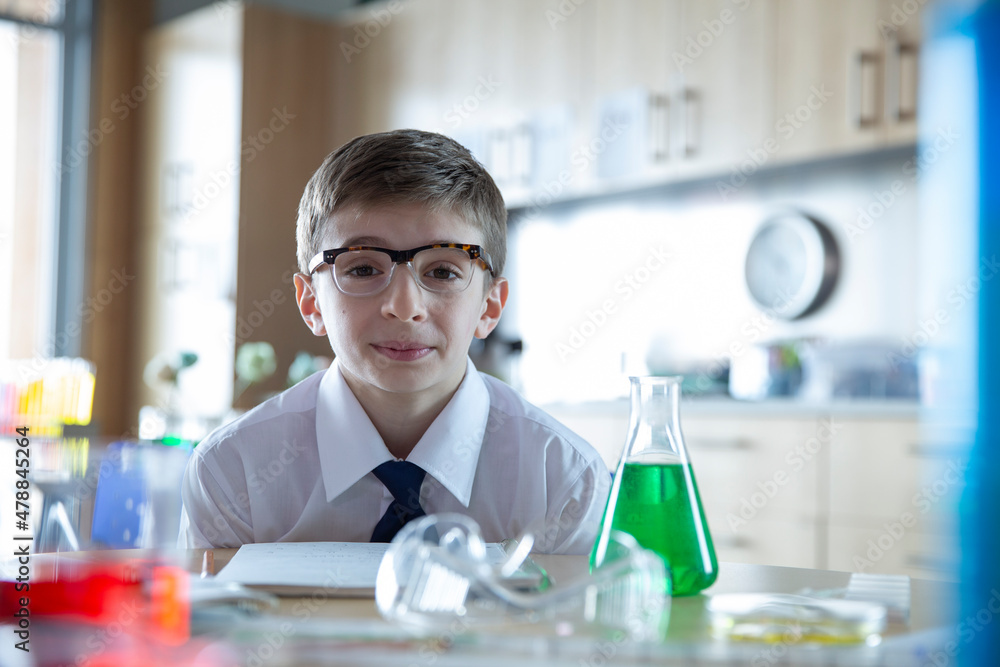 School boy conducting experiment in science classroom Stock Photo ...