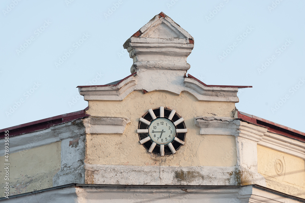 Urban architecture. A round clock on the facade of a 20th century brick ...