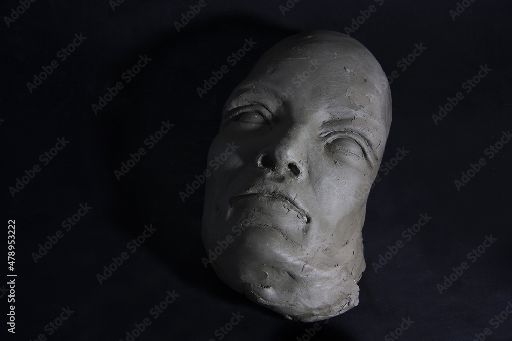 Distorted face in clay. Head sculpture in process of creation. Light ...