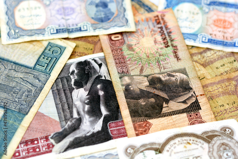 background of a stack of old Egyptian money banknotes of different ...